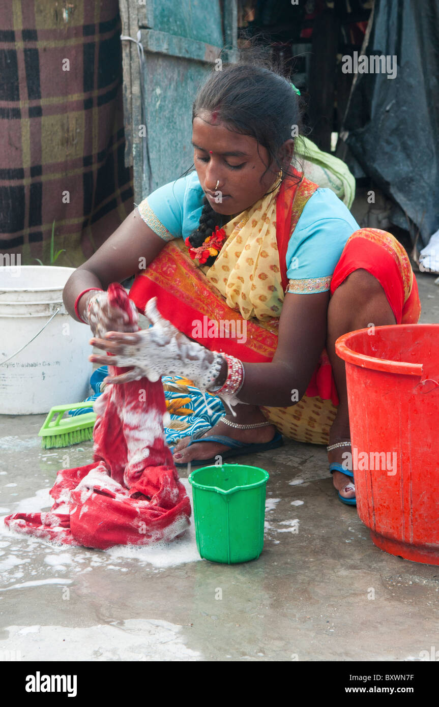 portrait of an Indian woman washing clothes at a homeless camp in ...
