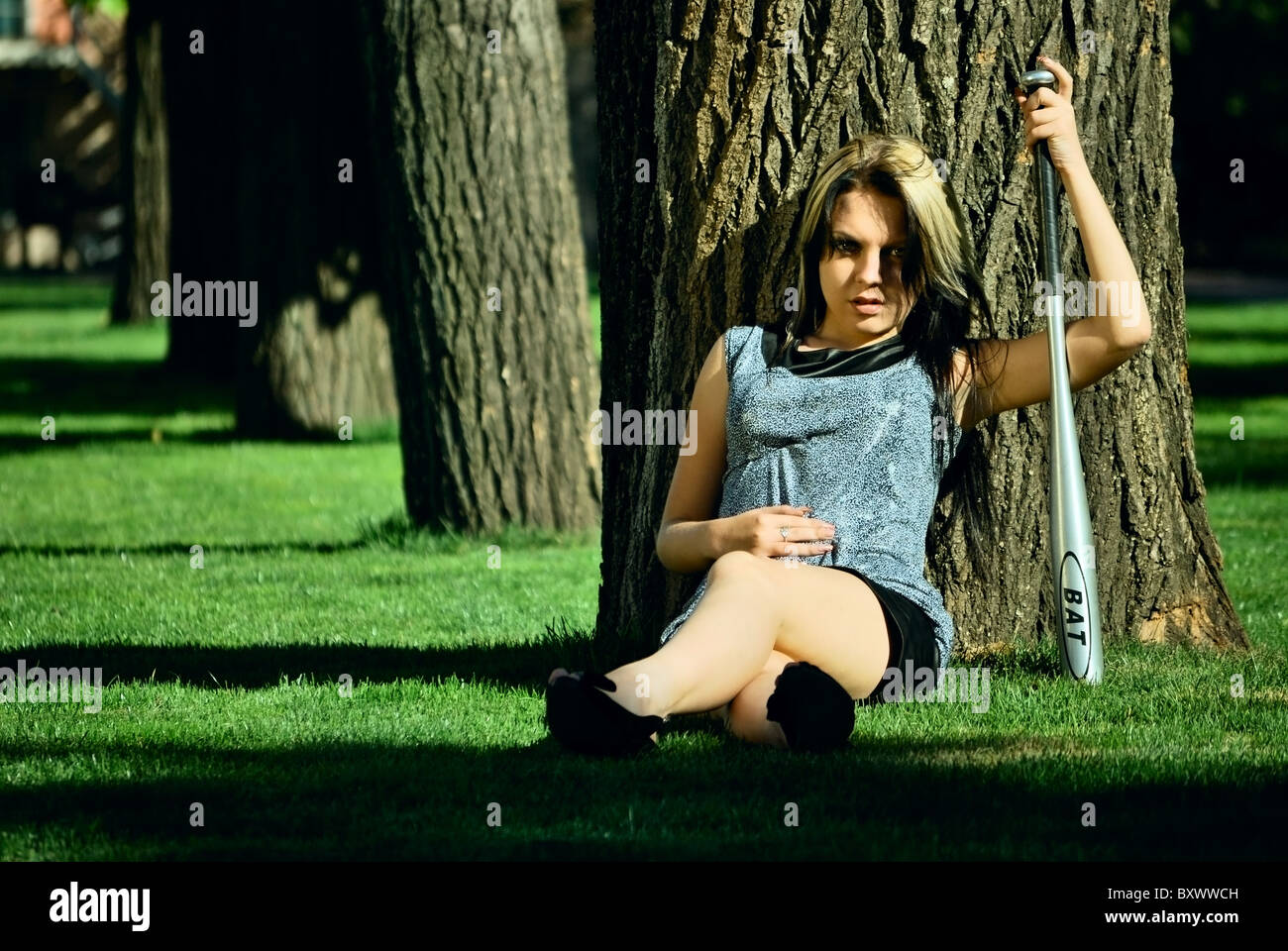 aggrasive girl with bita sitting on lawn Stock Photo - Alamy