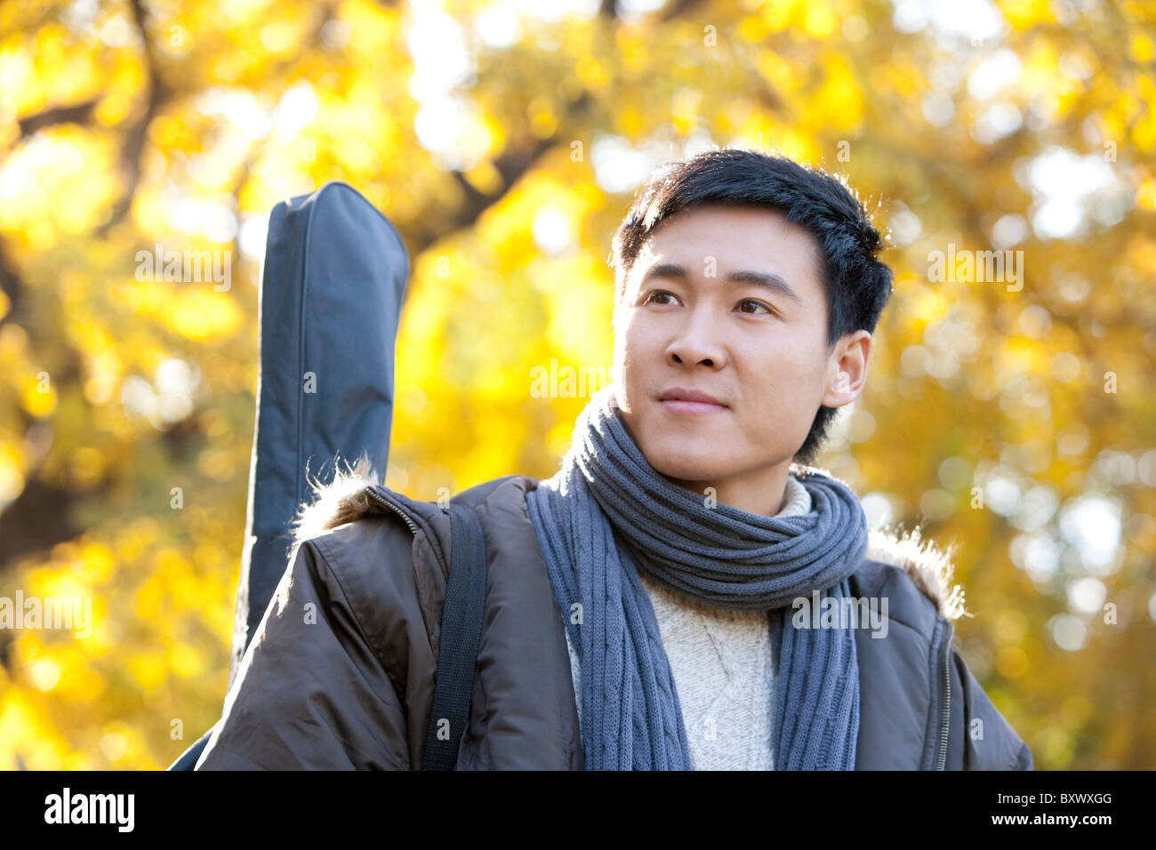 Young Man Carrying Guitar Case Stock Photo - Alamy