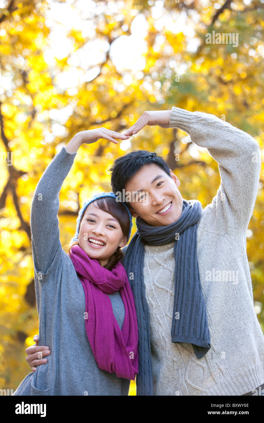 Young Couple Making a Heart with their Arms Stock Photo - Alamy