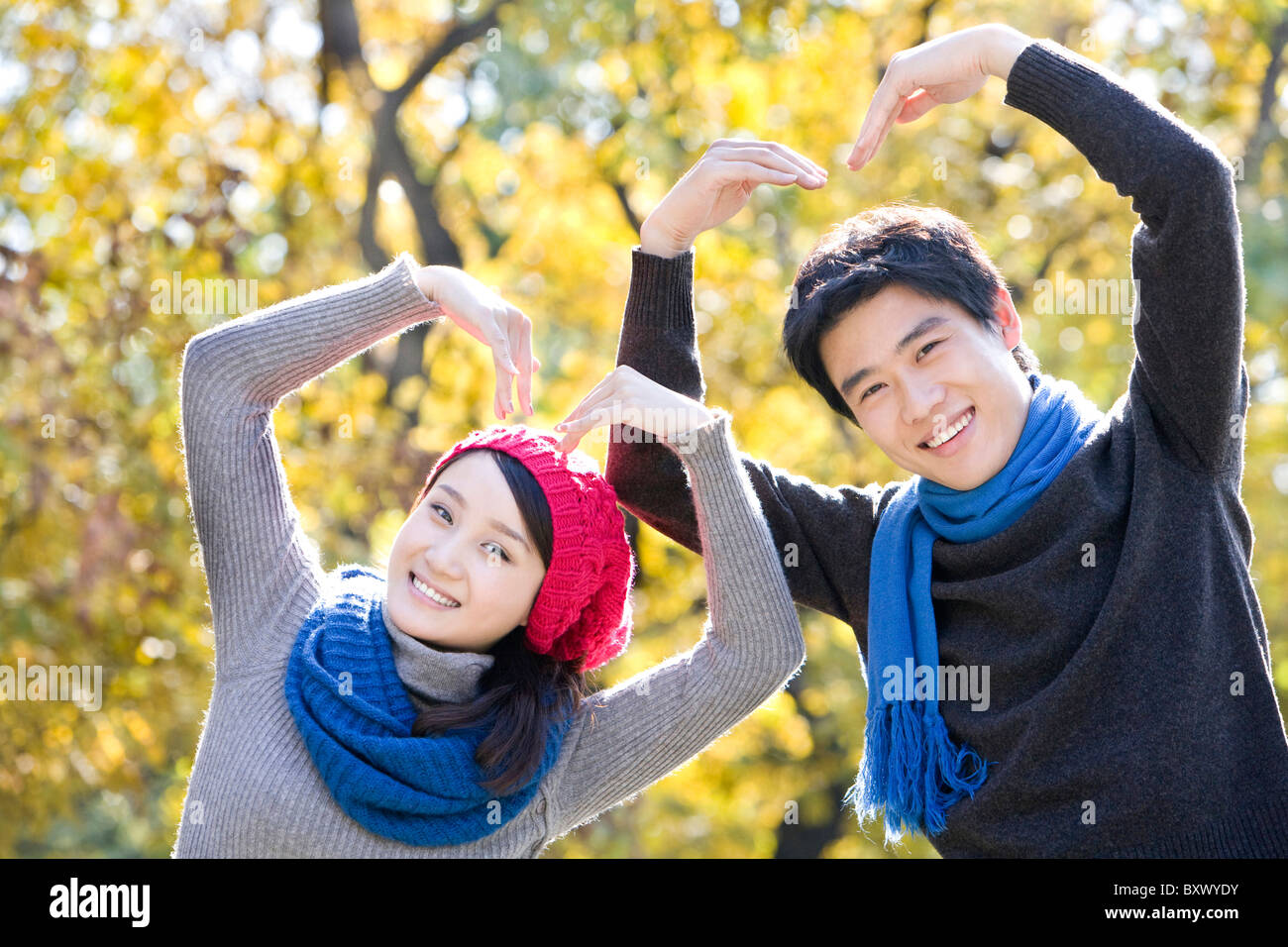Young Couple Making Hearts with their Arms Stock Photo - Alamy
