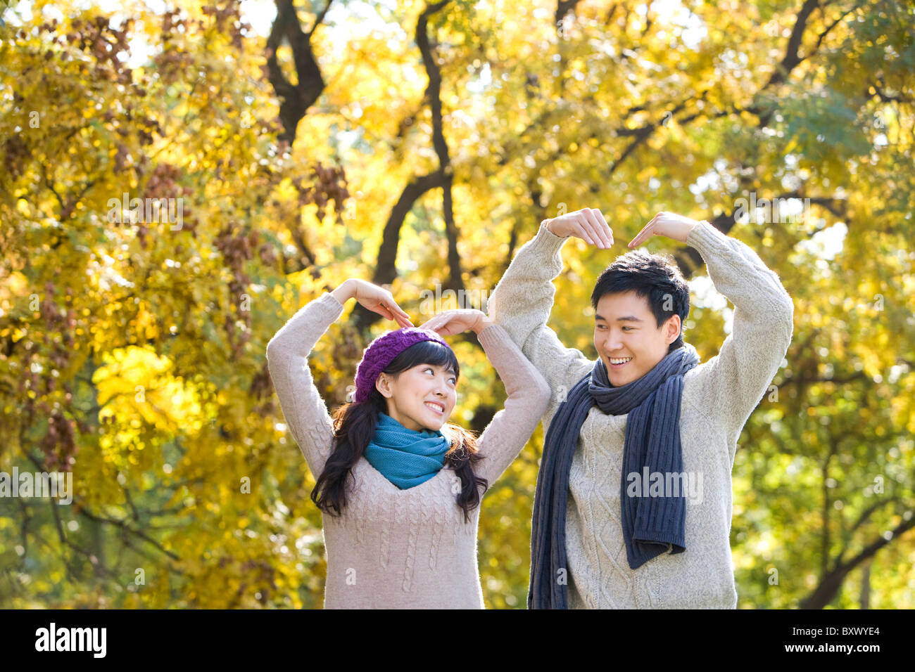 Young Couple Making Hearts with their Arms Stock Photo - Alamy