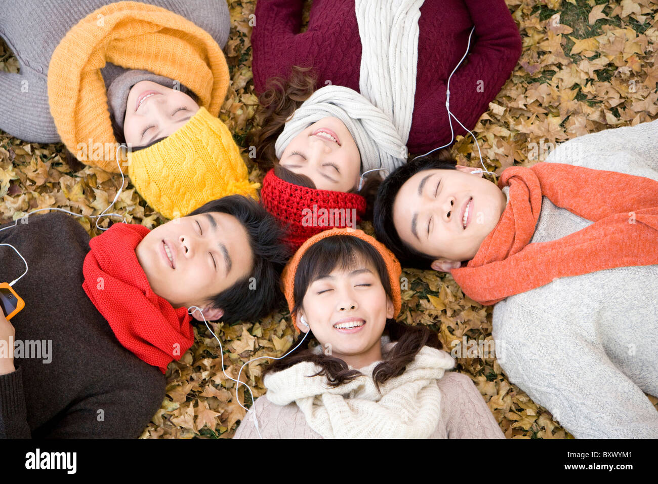 Friends Lying Amongst Maple Leaves Shaing MP3 Players Stock Photo - Alamy