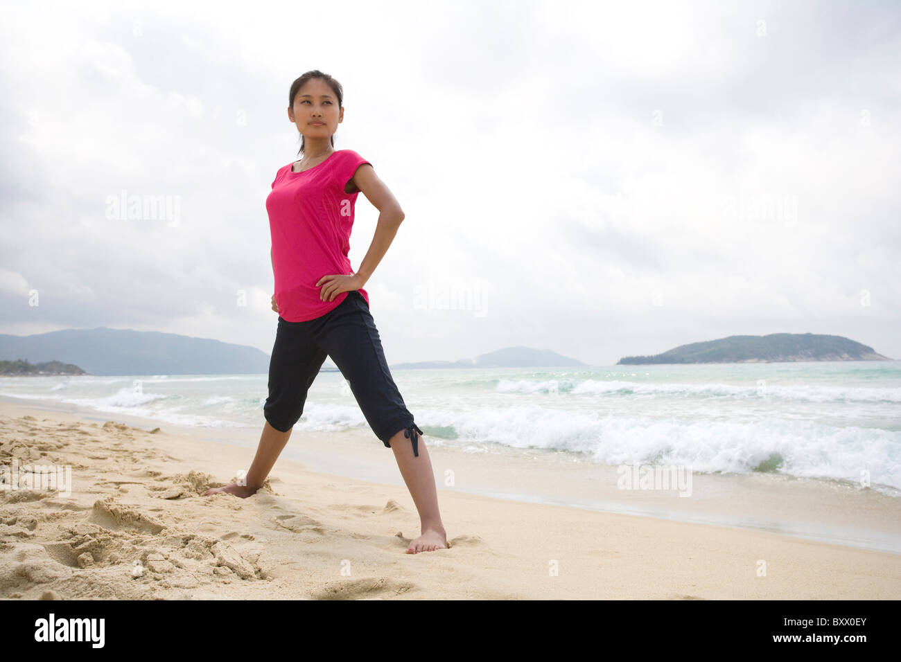 Young woman stretching by the sea Stock Photo - Alamy