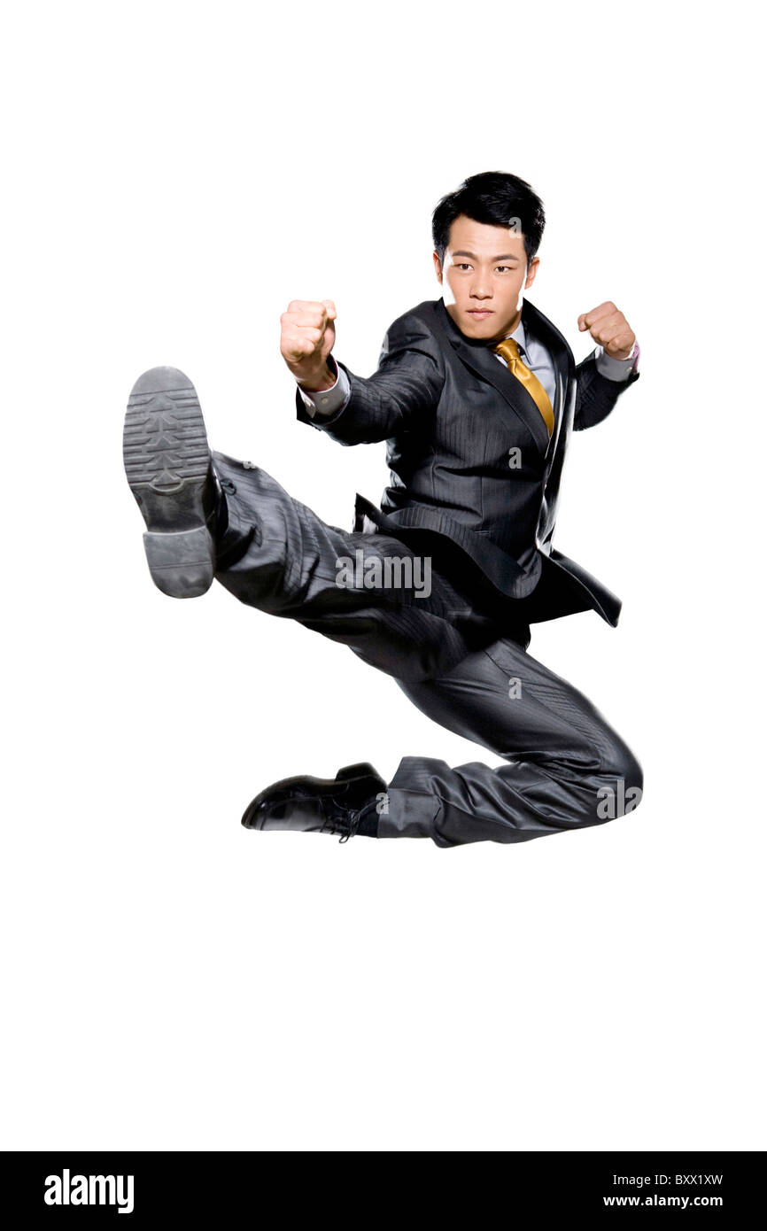 Businessman in martial arts position mid-air Stock Photo - Alamy