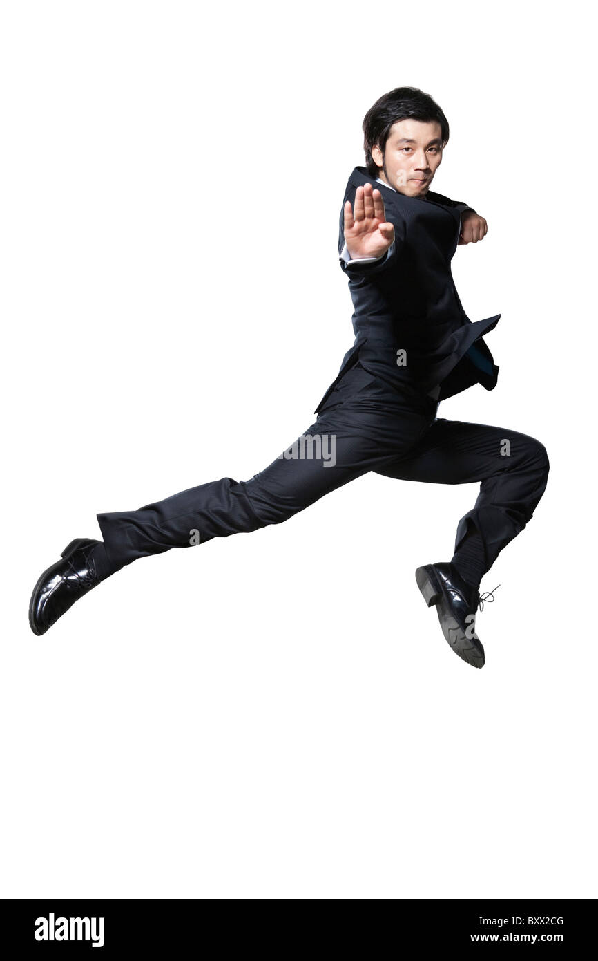 Businessman in martial arts pose mid-air Stock Photo - Alamy