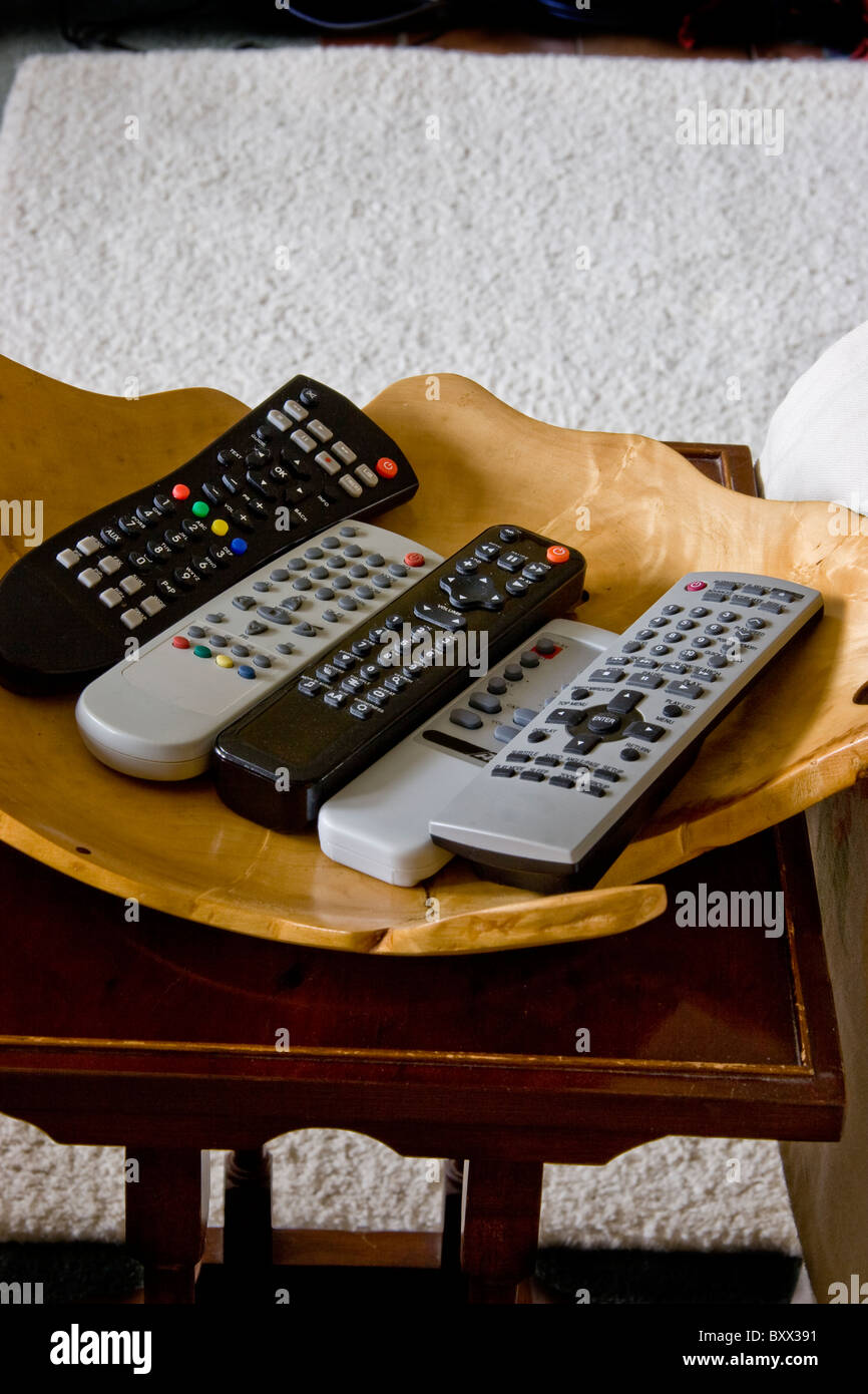 Electronic remotes in a wooden bowl Stock Photo - Alamy