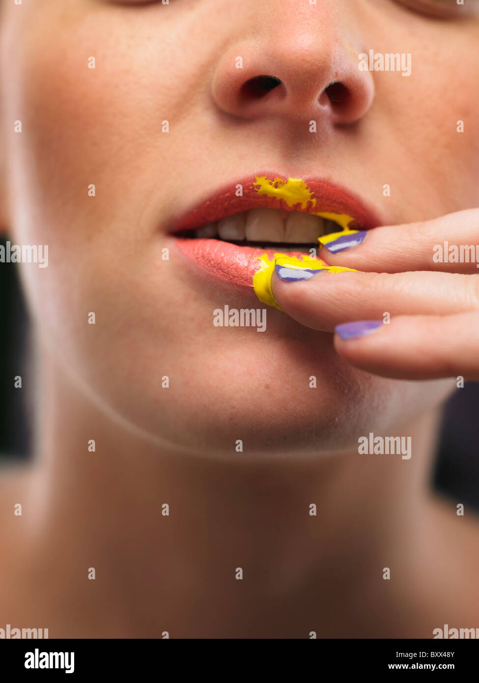 white womans hand smearing paint across her lips Stock Photo - Alamy
