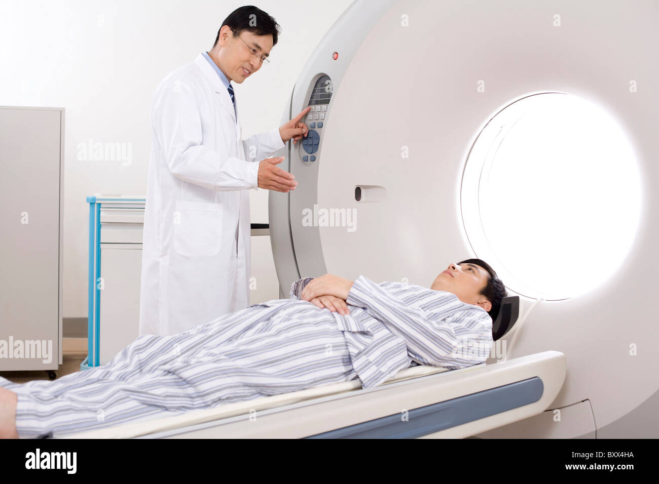 Medical professional helping a patient into a MRI scanner Stock Photo ...