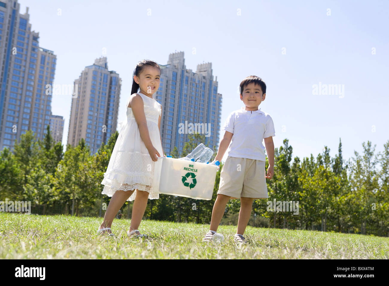 Children carrying a recycling bin Stock Photo - Alamy