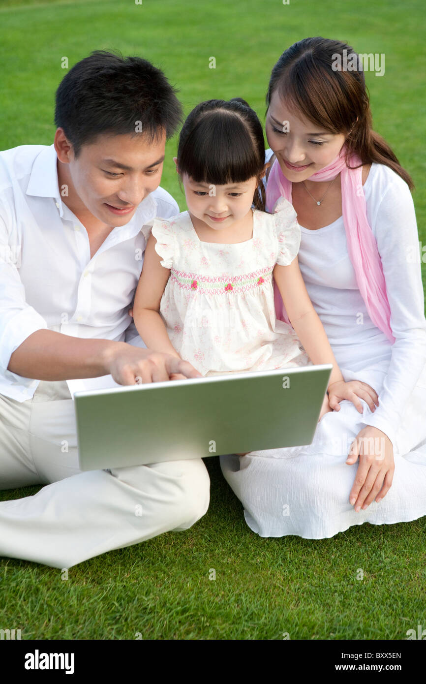 A young family using a laptop outdoors Stock Photo - Alamy