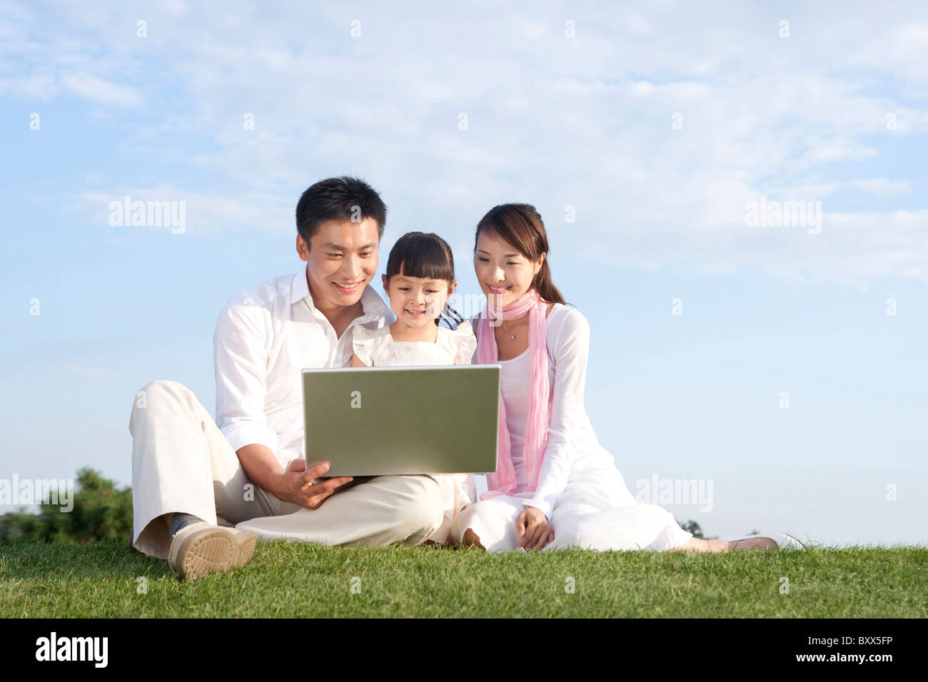 A young family using a laptop outdoors Stock Photo - Alamy