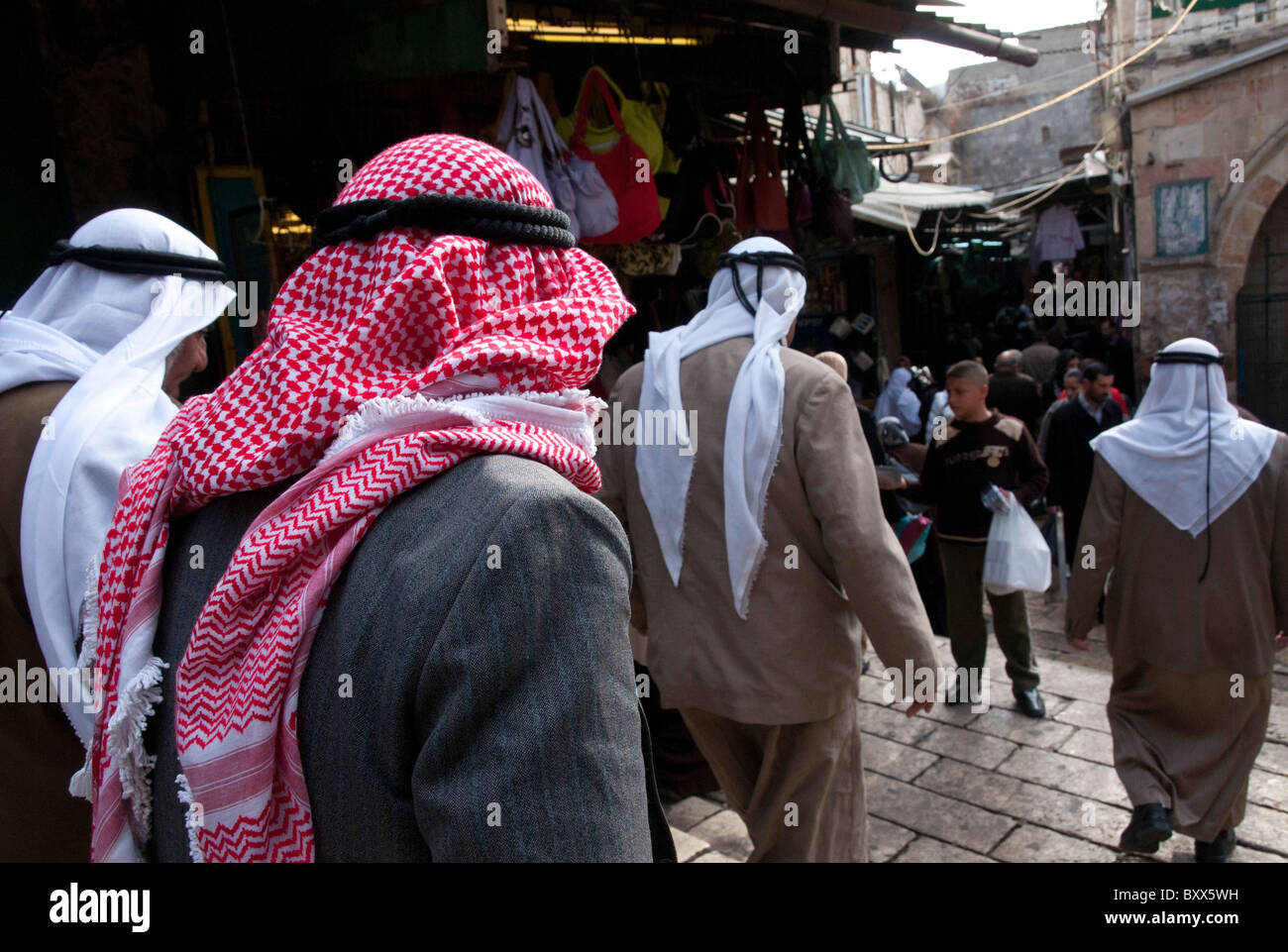 Close up of Palestinian men with keffiyeh walking in the street ...