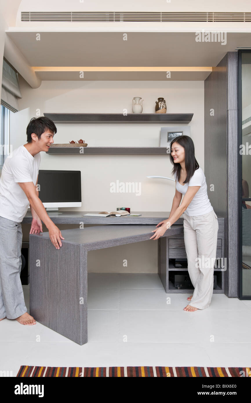 Man and Woman Moving Table Together Stock Photo - Alamy