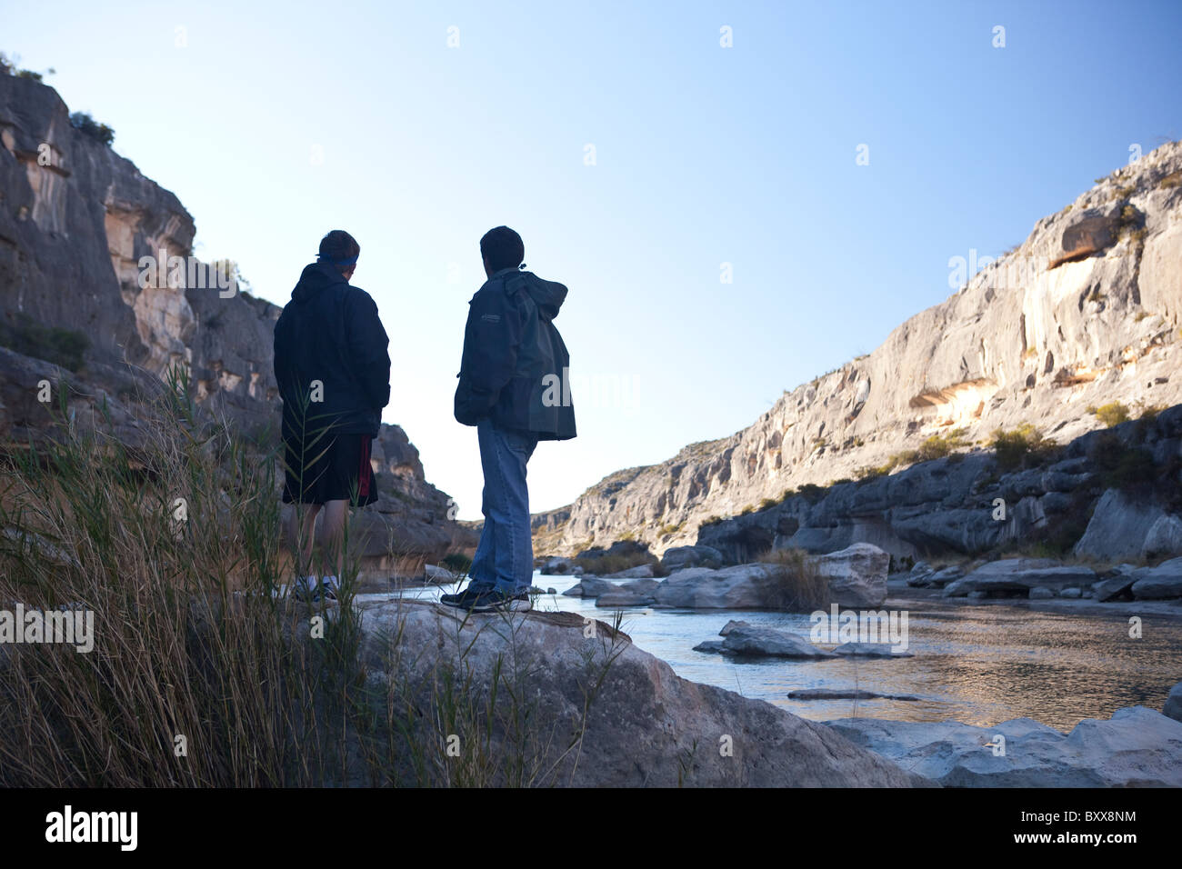 Teenage hikers admire dolomitic limestone cliffs on the Pecos River ...