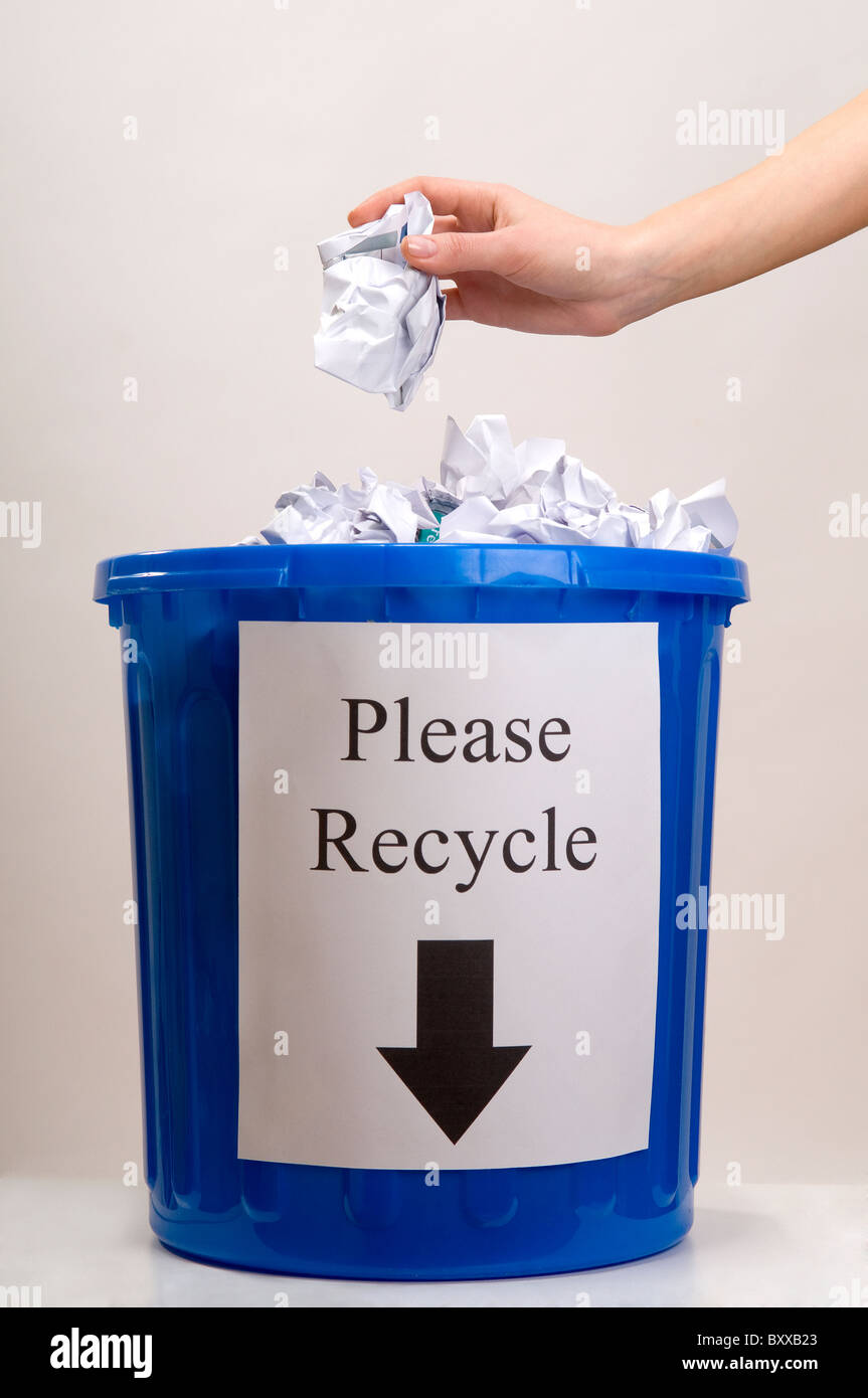 A person putting a paper in a recycling bin Stock Photo - Alamy