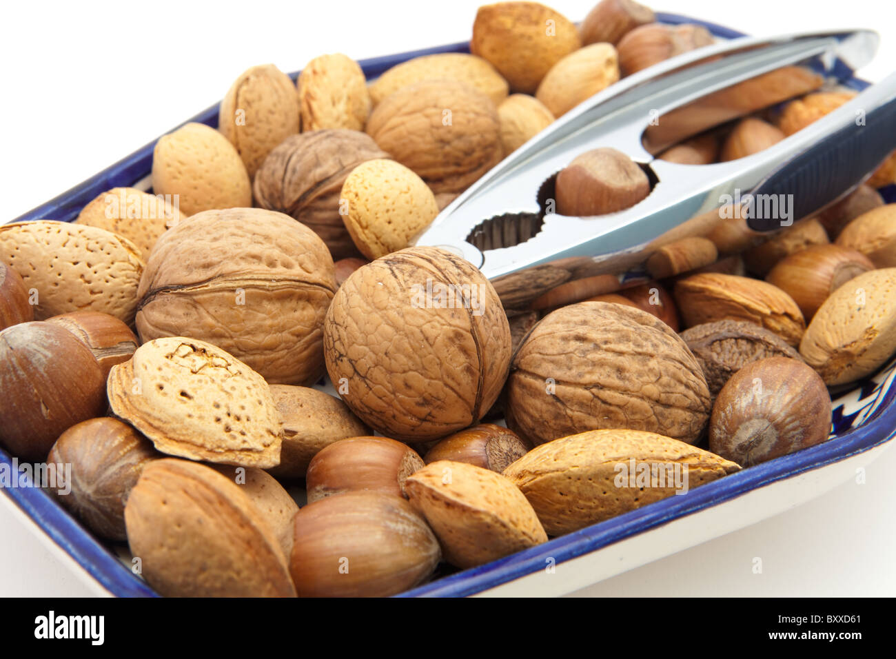 Close up of a plate of mixed nuts with a metal cracker Stock Photo - Alamy