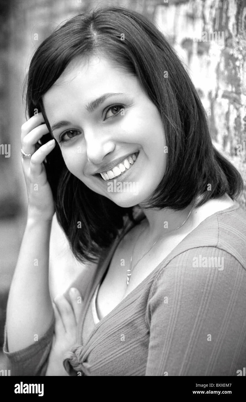 beautiful young woman model smiles outdoors near brick wall Stock Photo ...
