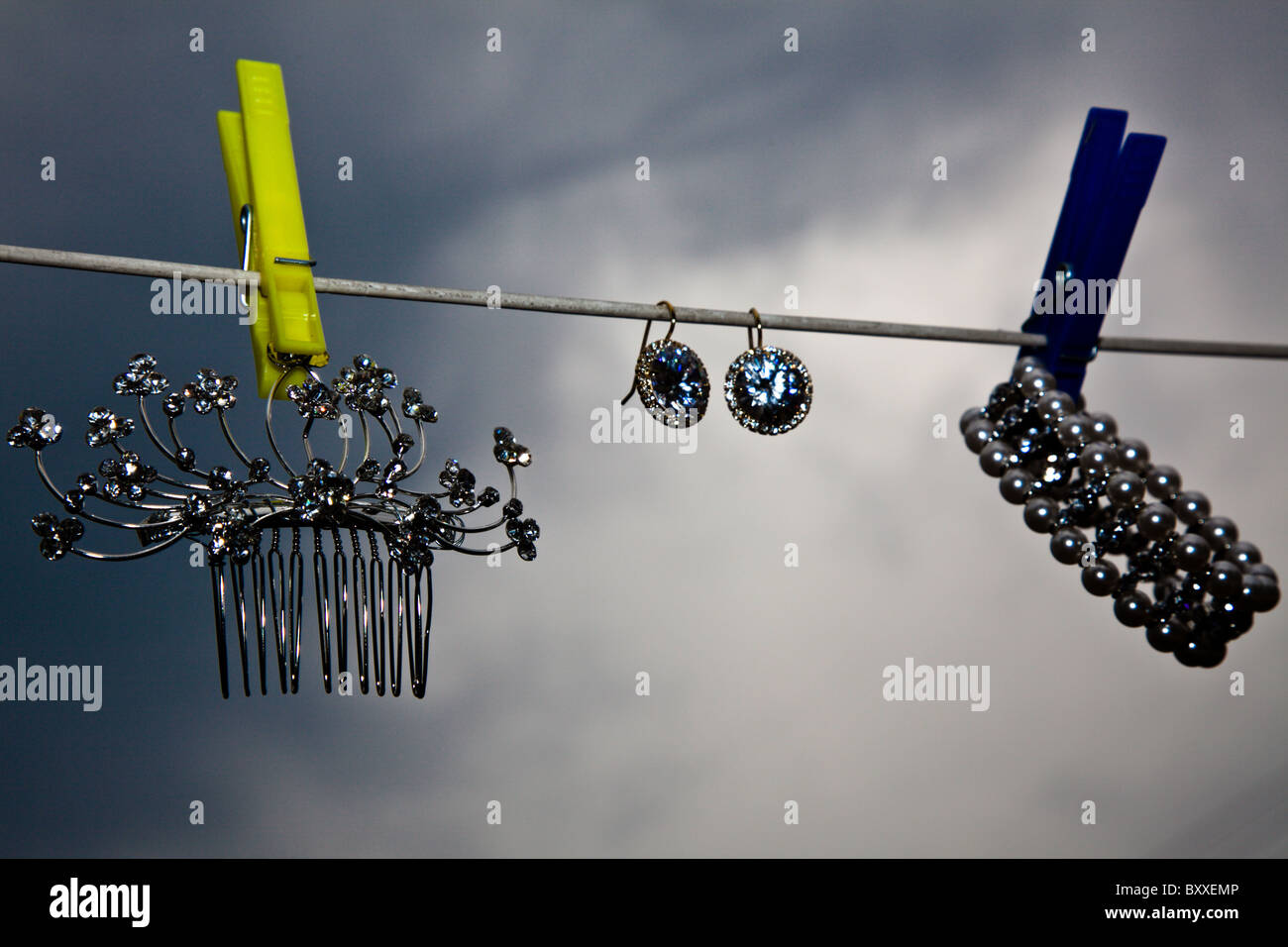 elegant jewelry hung on a laundry line with colorful clothespins and ...