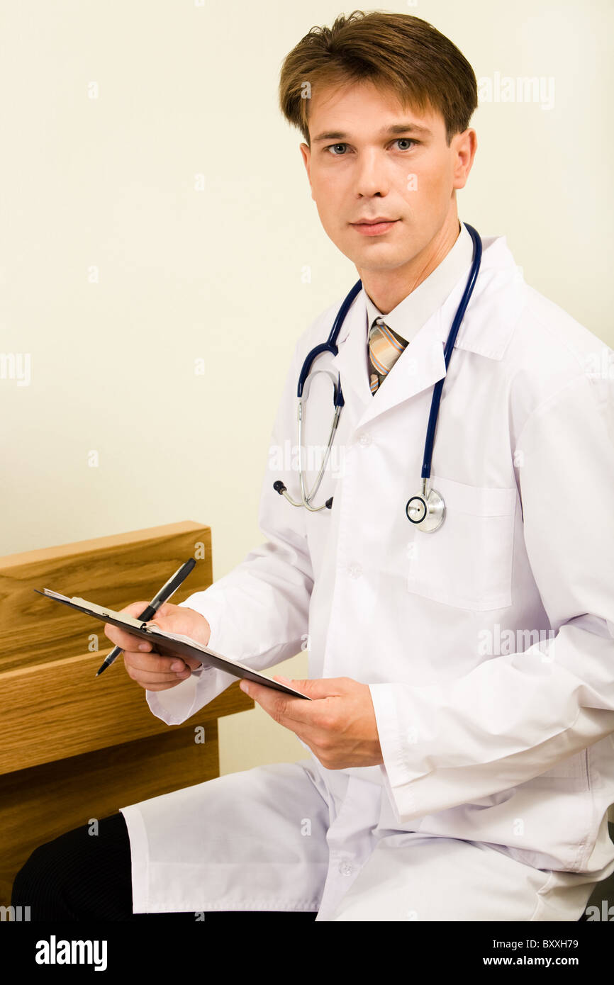 Portrait of confident doctor with stethoscope on his shoulder looking ...