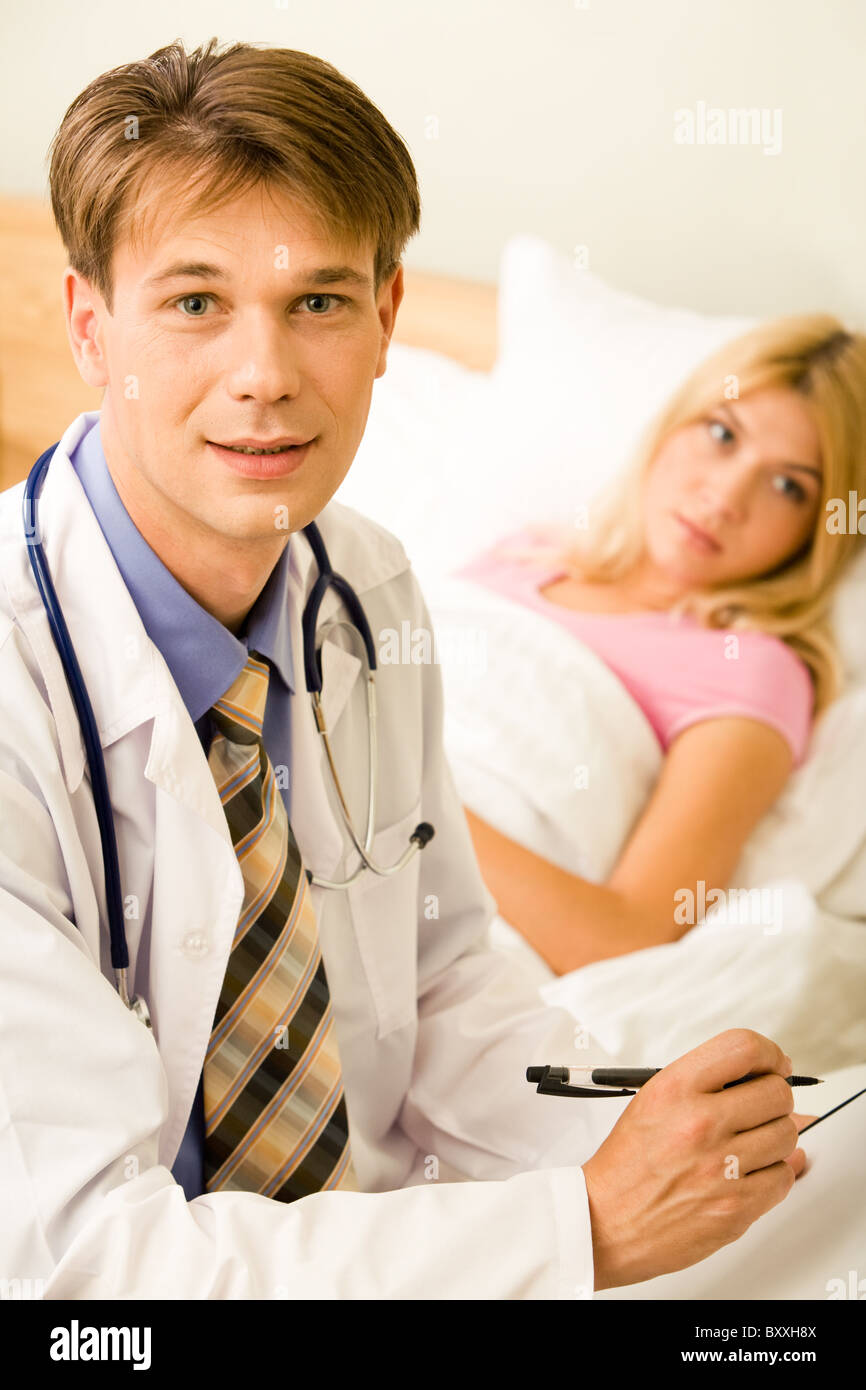 Portrait of handsome doctor looking at camera on background of his ...