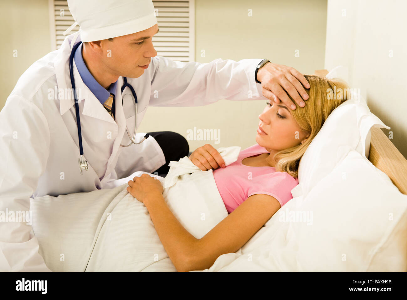 Photo of male doctor touching patient woman’s head in hospital Stock ...