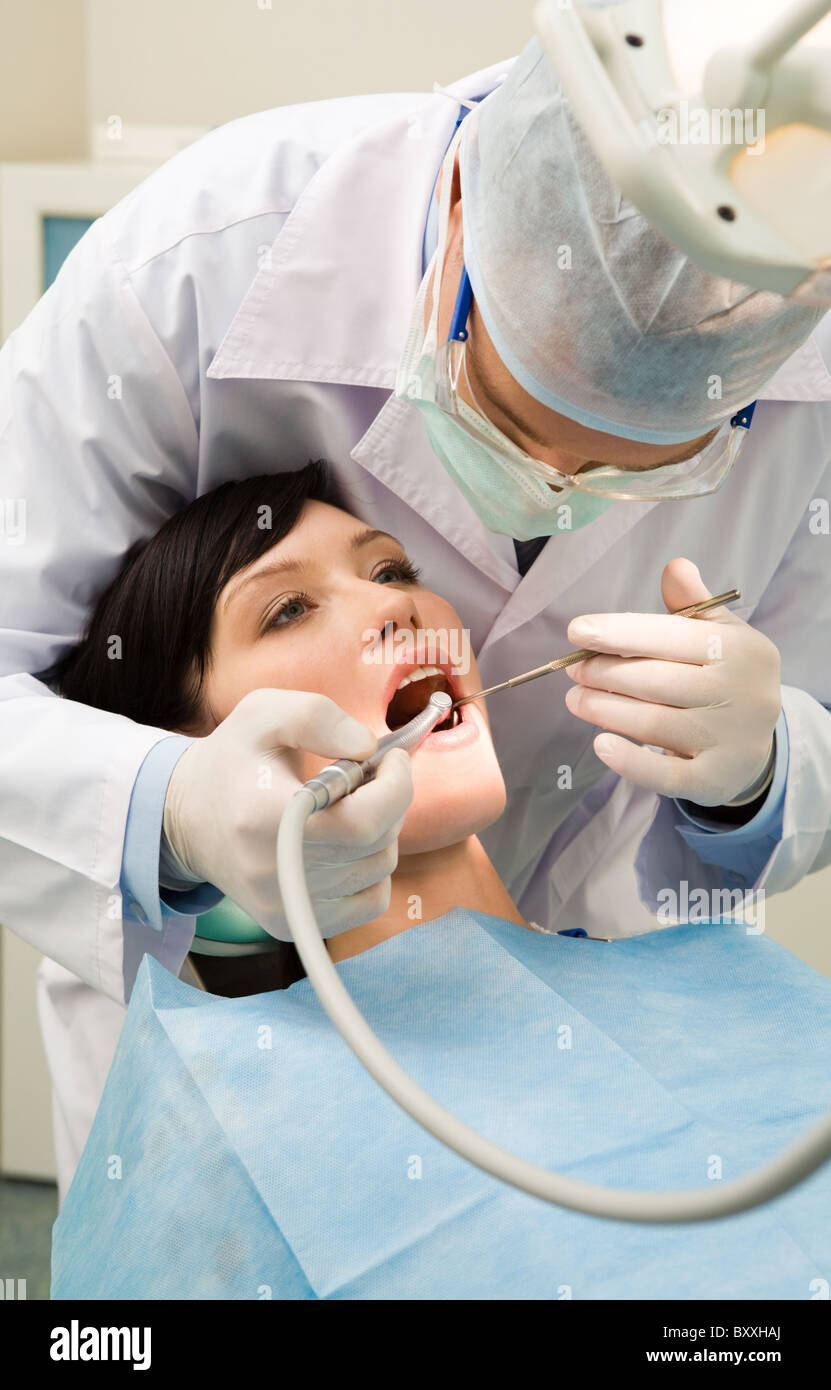 Vertical image of female patient with dentist over her checking up ...