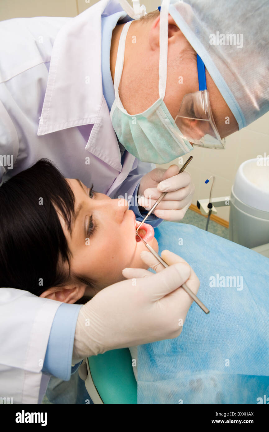 View from aside of young patient with open mouth while it being ...