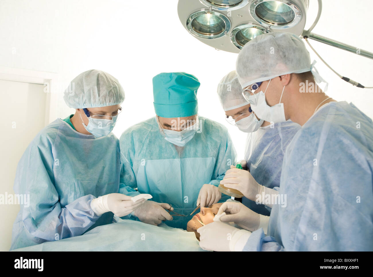 Portrait of four medical professionals performing an operation on woman ...