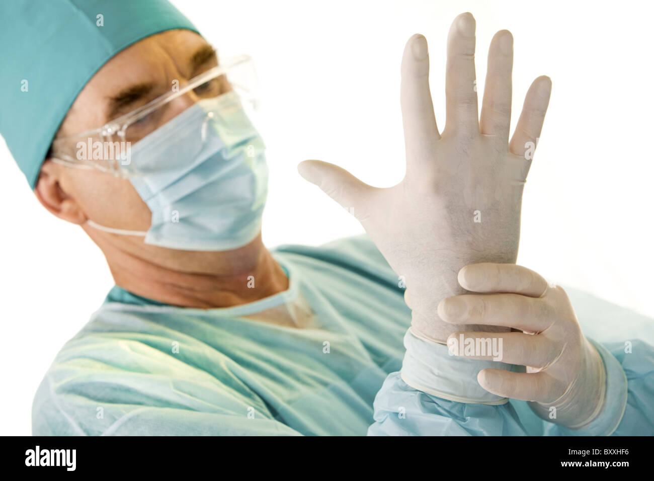 Portrait of doctor dressing medical gloves after operation Stock Photo ...