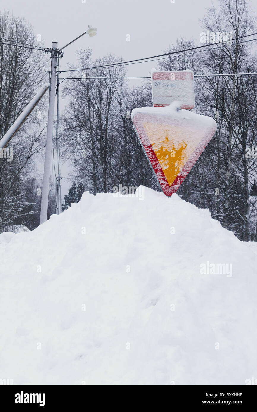 Buried under the snow traffic sign- give way Stock Photo - Alamy