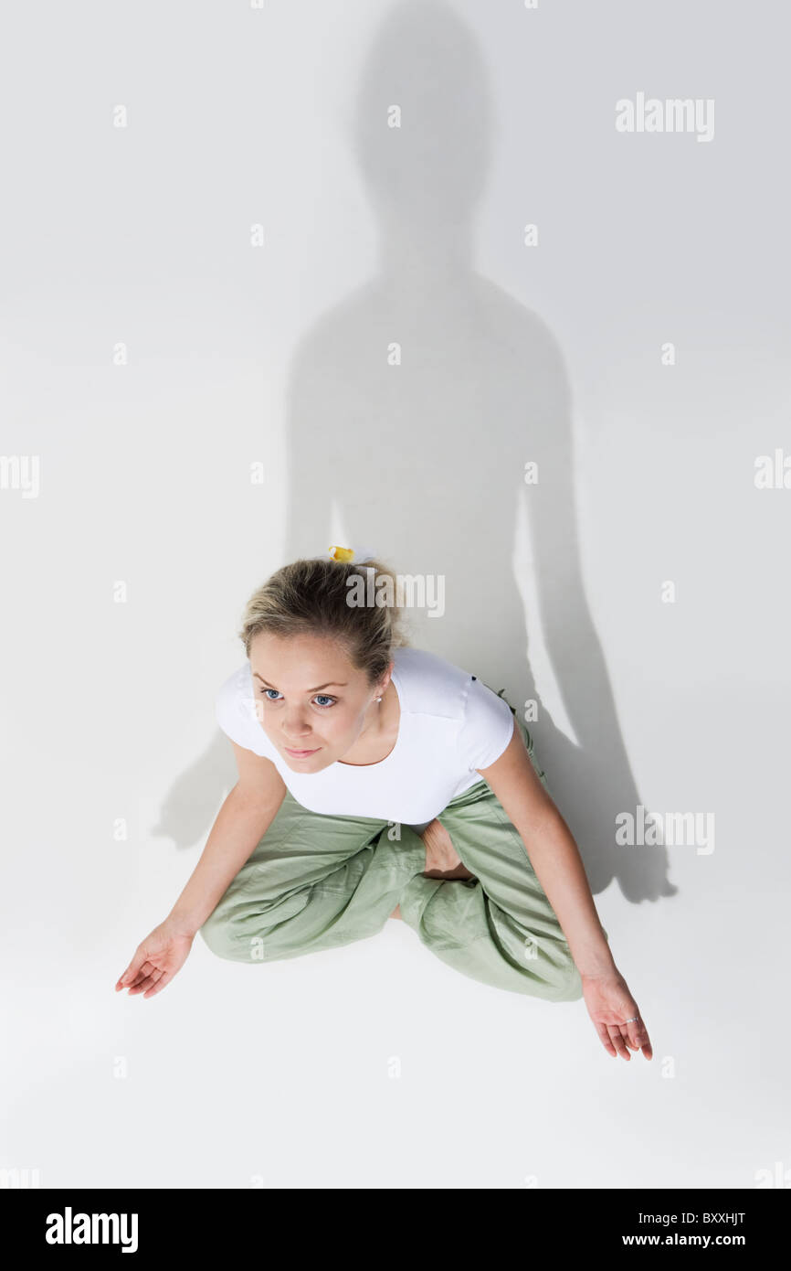 Above view of young woman meditating in pose of lotus and looking ...
