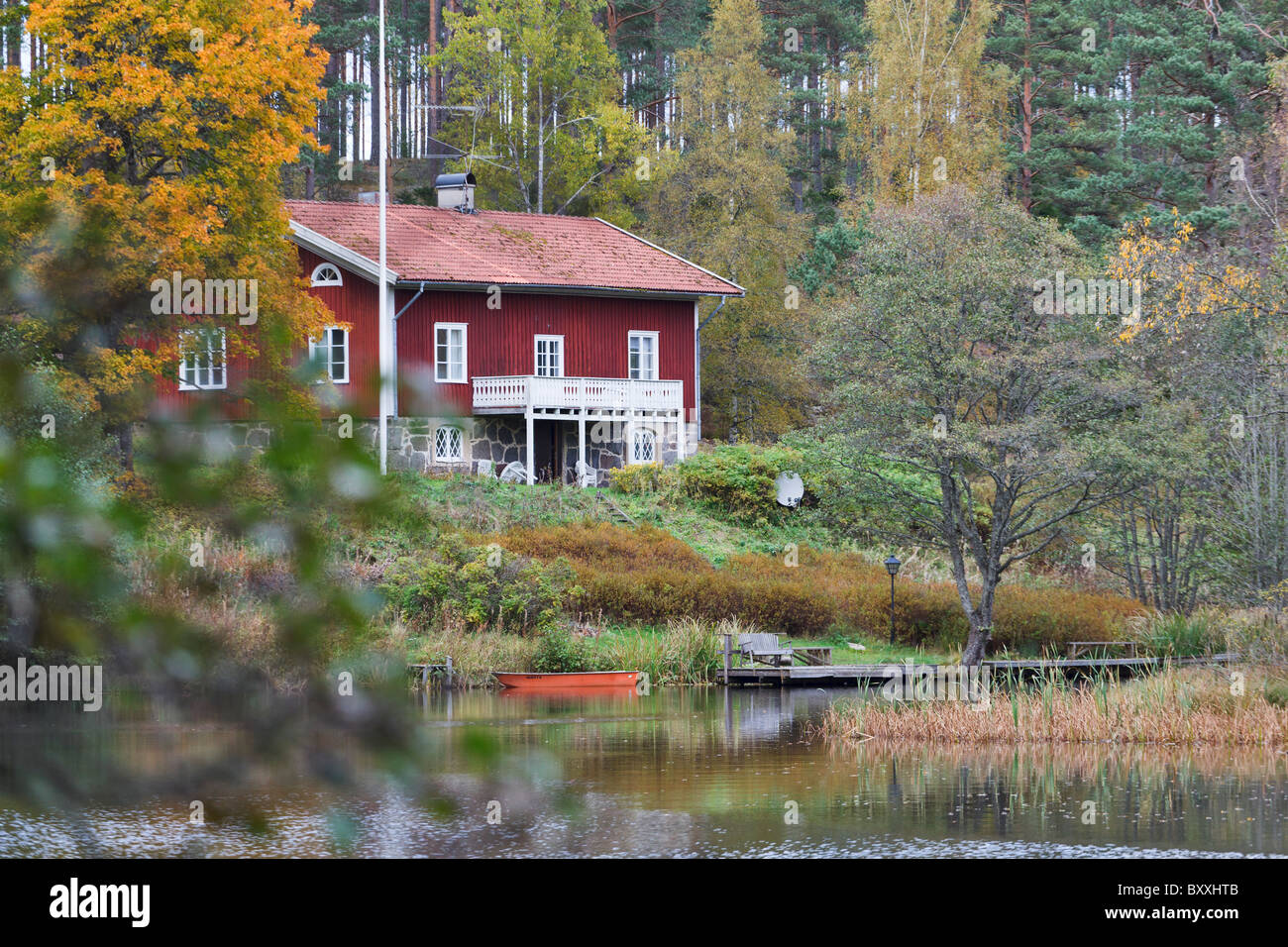 Red house in the forest at the lake Stock Photo - Alamy