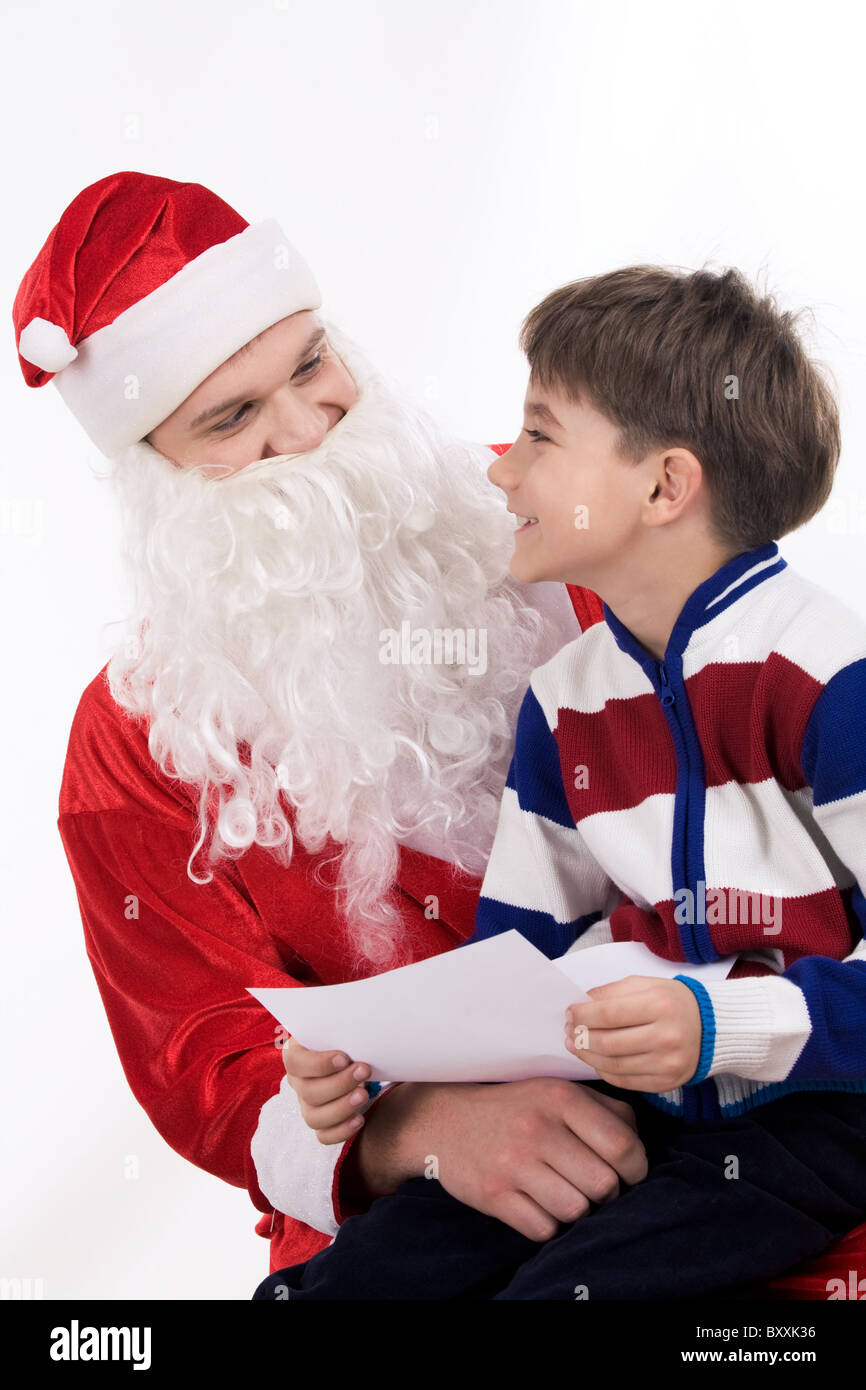 Merry Santa holding little boy on hands while he reading his letter ...