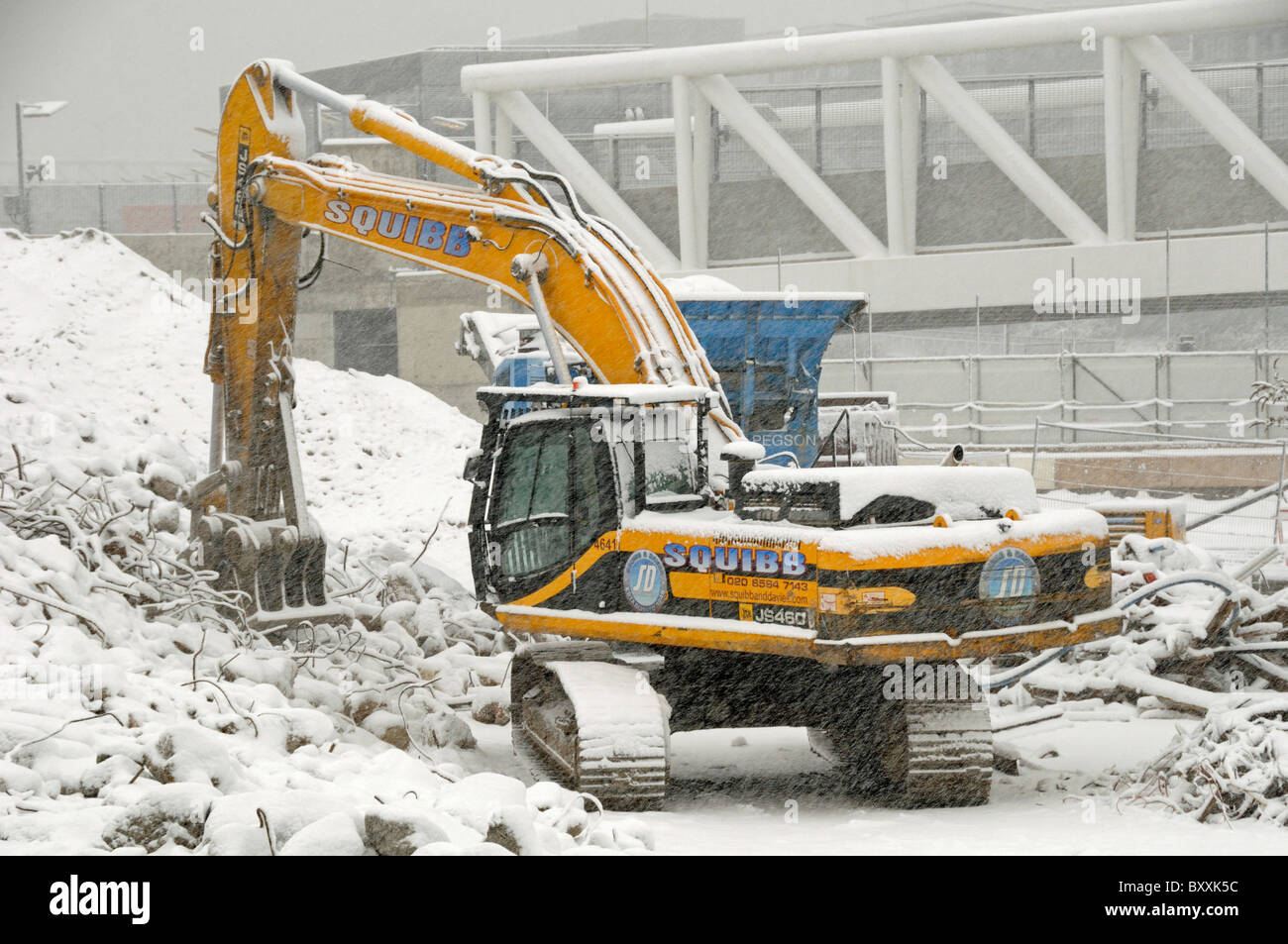 Squibb excavator in snow on demolition site Stock Photo - Alamy