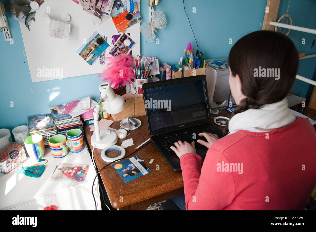 A girl student works at her laptop computer in her bedroom Stock Photo ...