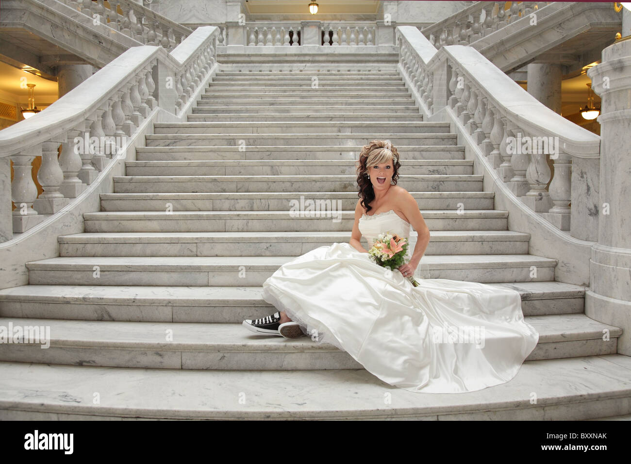 beautiful excited bride sitting on grand marble staircase Stock Photo ...