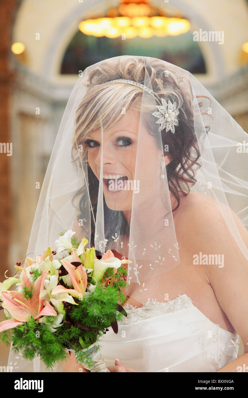beautiful excited bride holding bouquet beneath veil close-up Stock ...