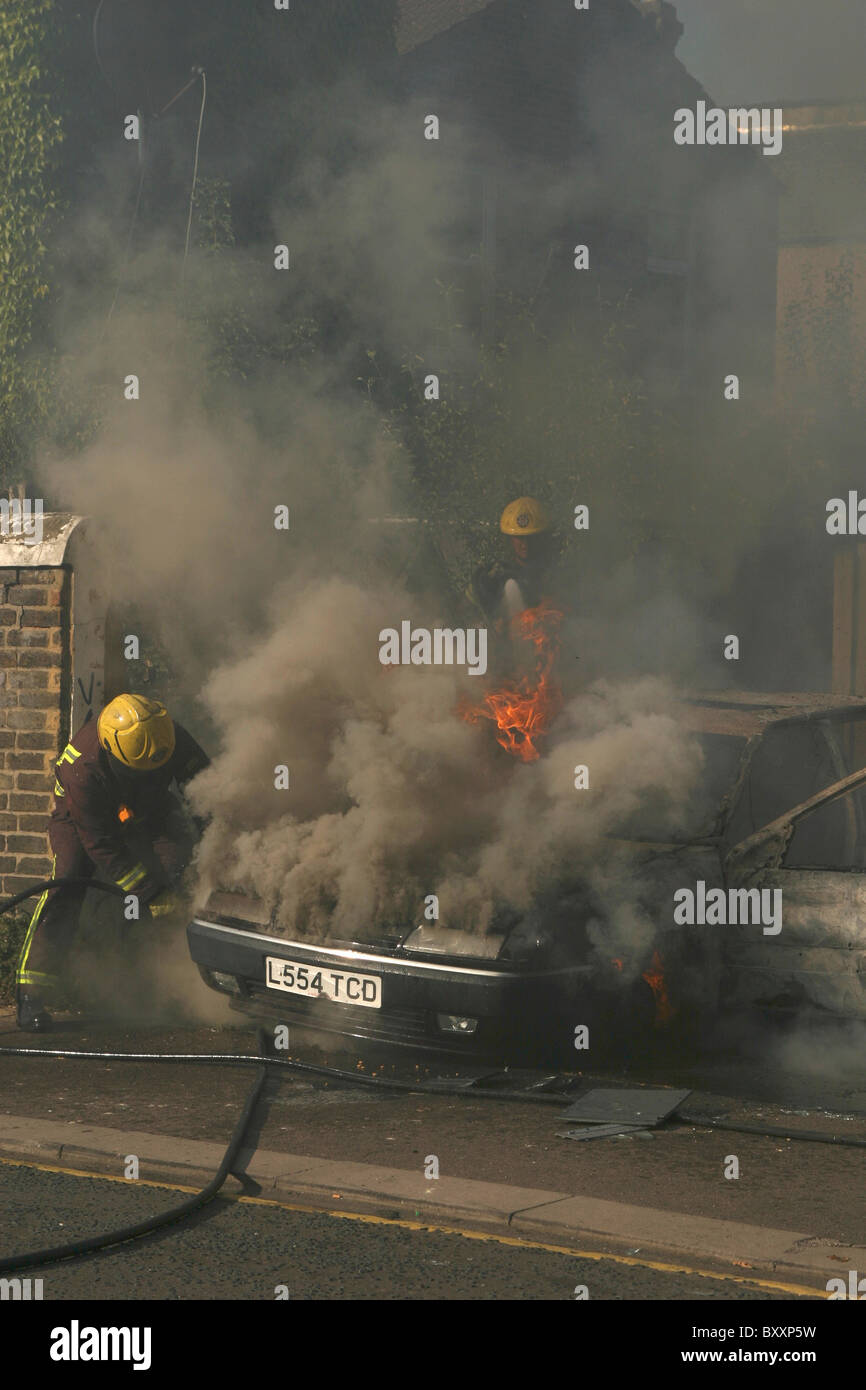 Firefighters battle a car fire Stock Photo - Alamy
