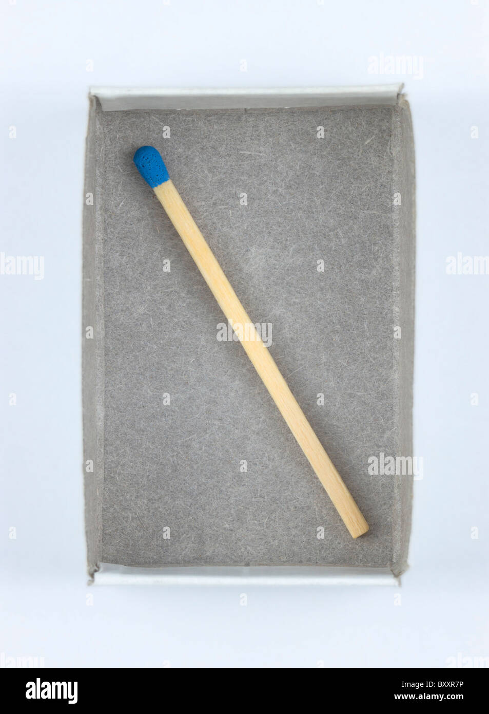 A single blue-tipped safety match inside an open matchbox; on white ...
