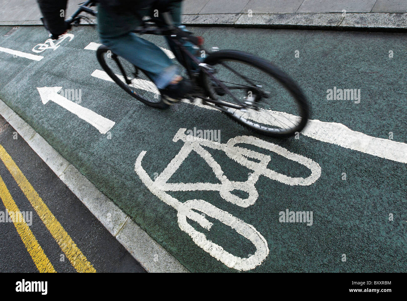 Cyclist on two way cycle lane on urban street UK Stock Photo - Alamy