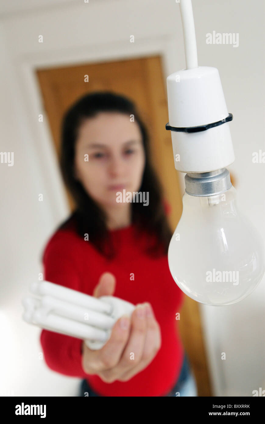 Woman putting in energy saving light bulb Stock Photo - Alamy