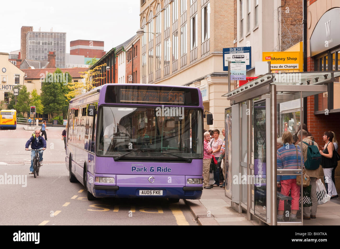People boarding a bus at a bus stop in Norwich , Norfolk , England ...