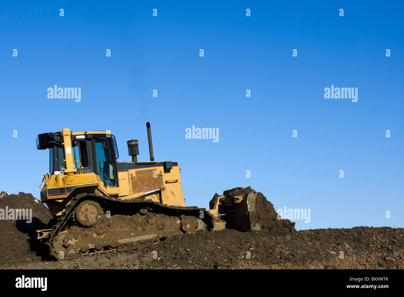 Bulldozer in operation moving dirt and clearing the land. Room for copy ...