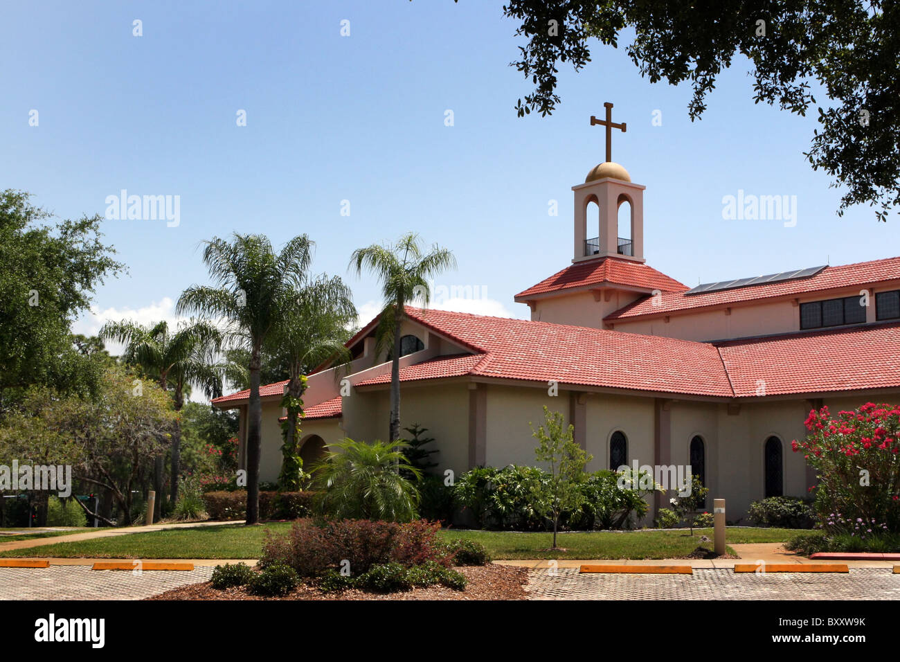 A cross tops the bell tower of a modern day catholic church Stock Photo ...