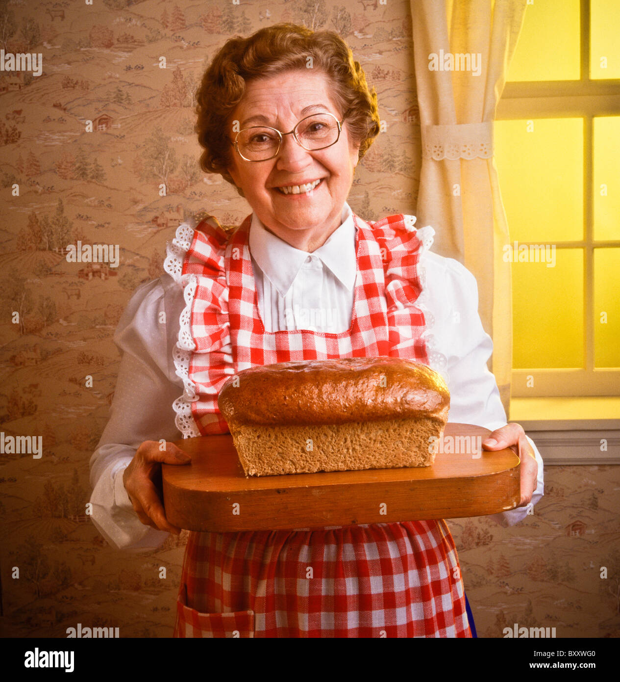 One elderly senior citizen farmers wife displays fresh made loaf of ...