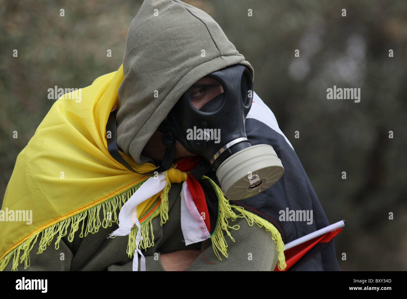 A Palestinian demonstrator wears a gas mask during a weekly rally ...