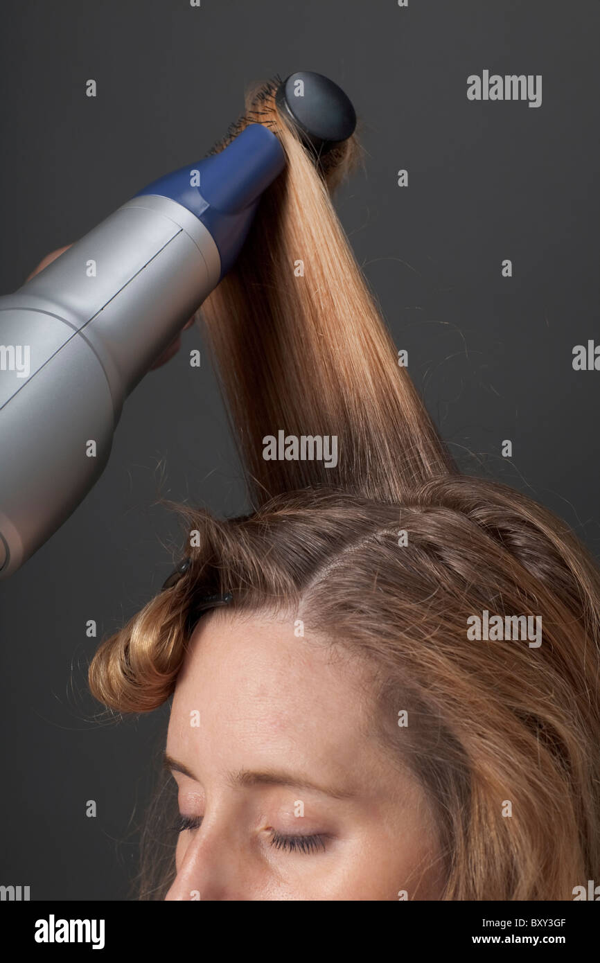 Hair stylist blow drying hair of customer Stock Photo - Alamy