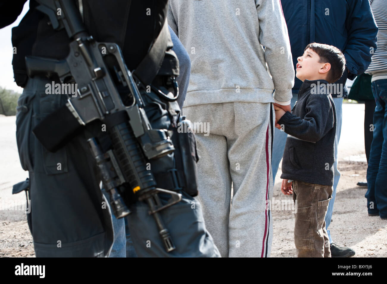 A Palestinian child watches Israeli security agents guarding a building ...