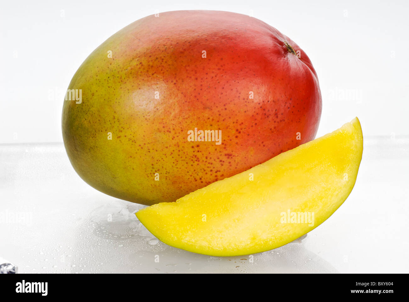One whole mango and one mango slice isolated on white background Stock ...
